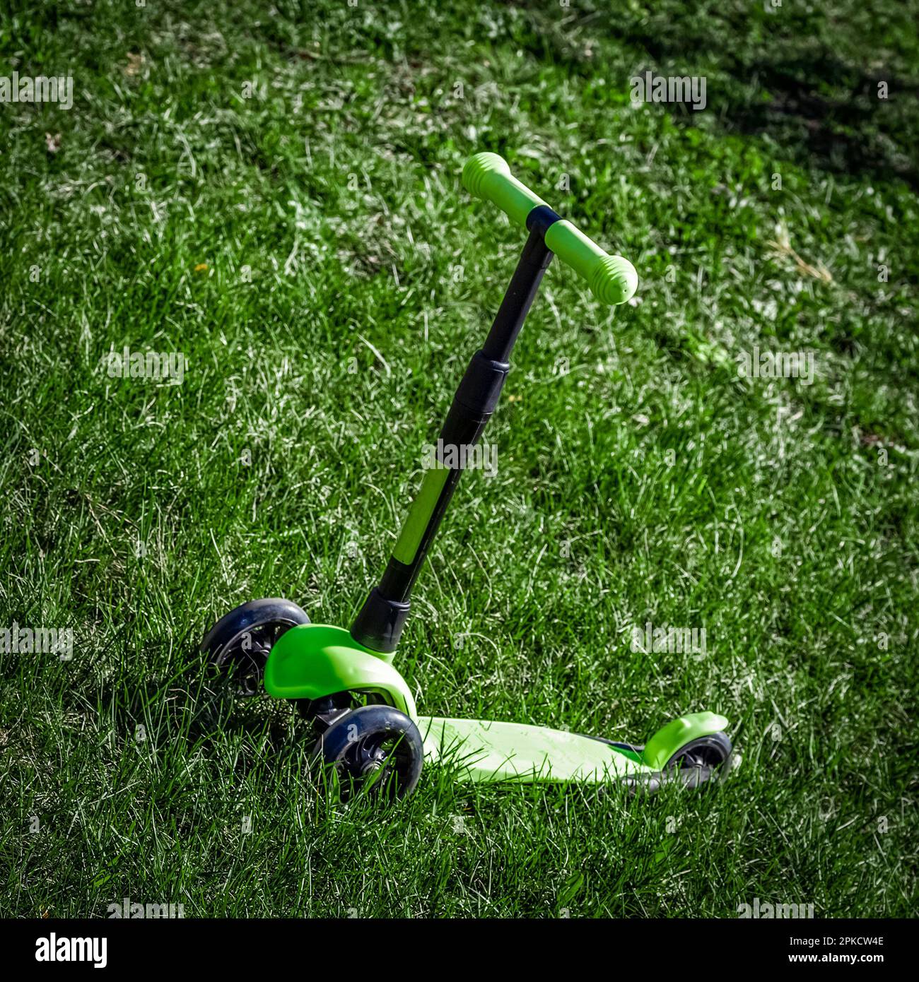 Children's green scooter stands in the meadow Stock Photo - Alamy