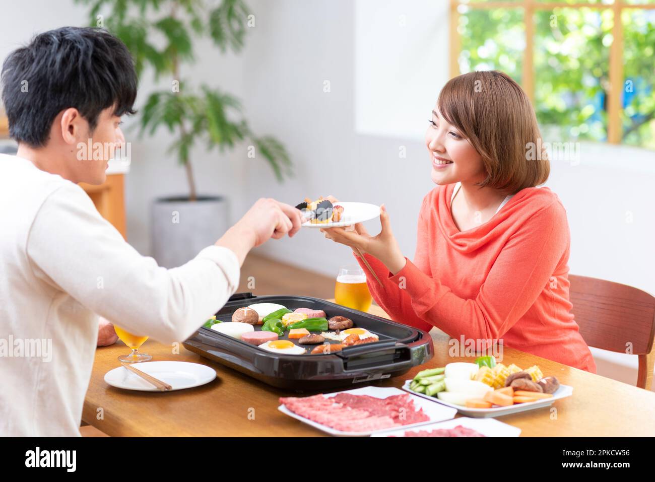 A couple in their 20s eating Yakiniku with draft beer Stock Photo - Alamy