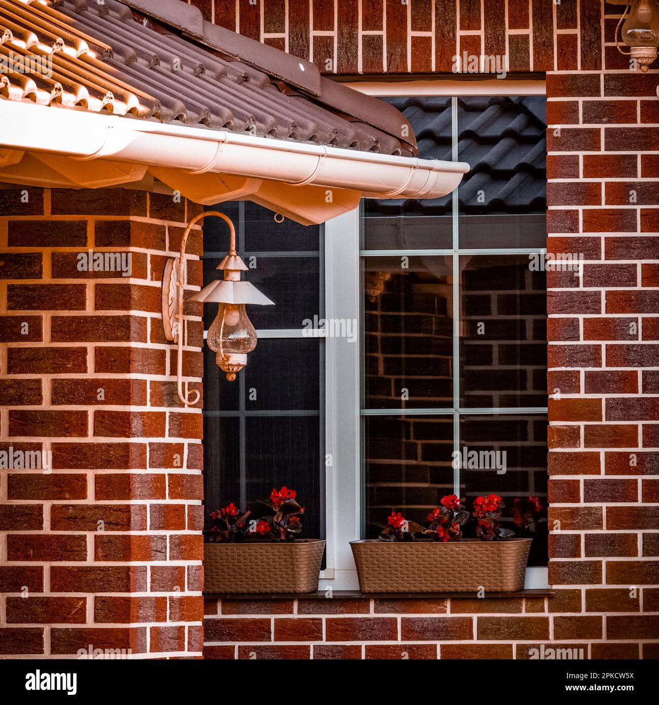 A window with flowers of a private brick house overlooking the backyard ...