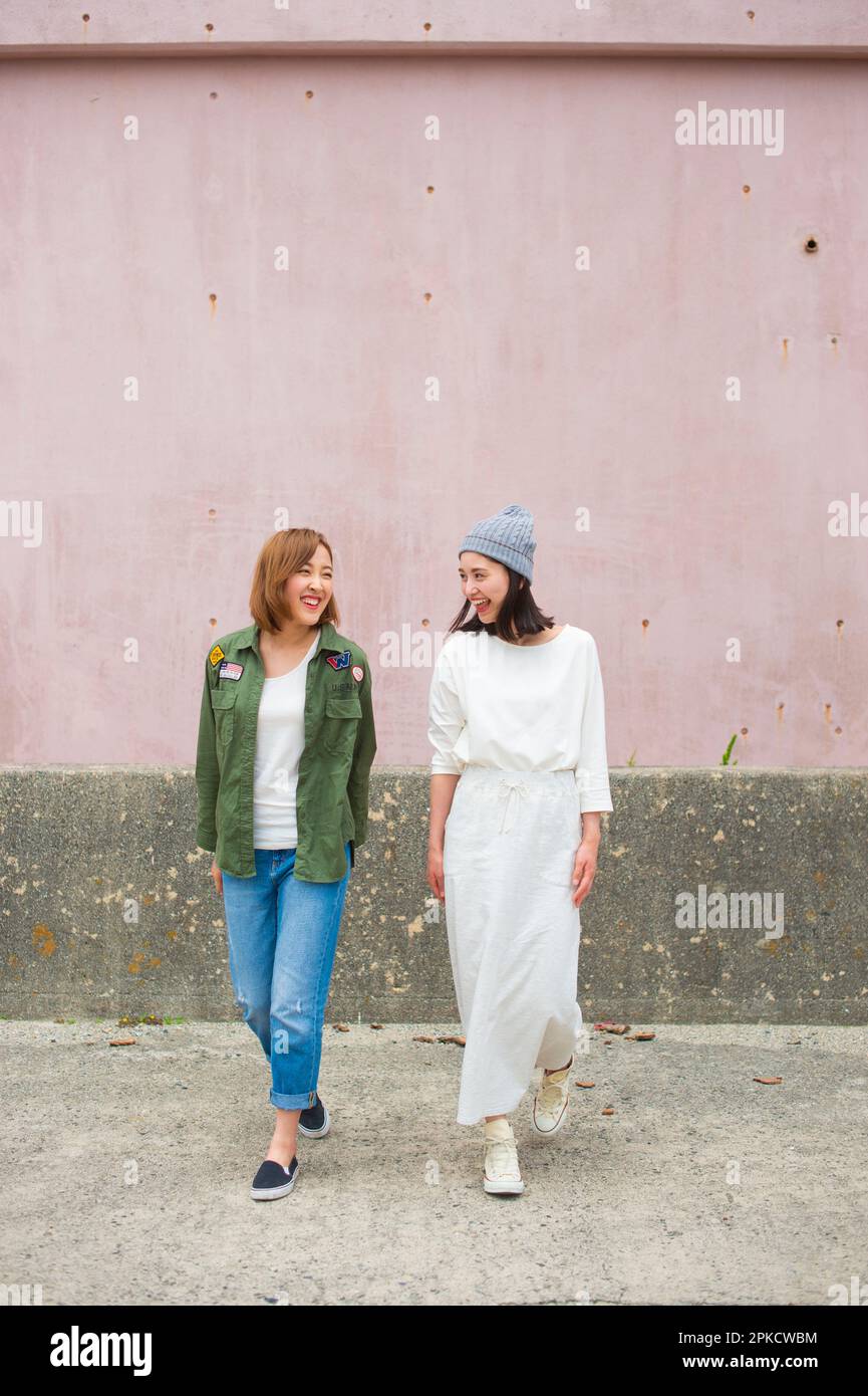 2 women in their 20s talking with friends Stock Photo - Alamy