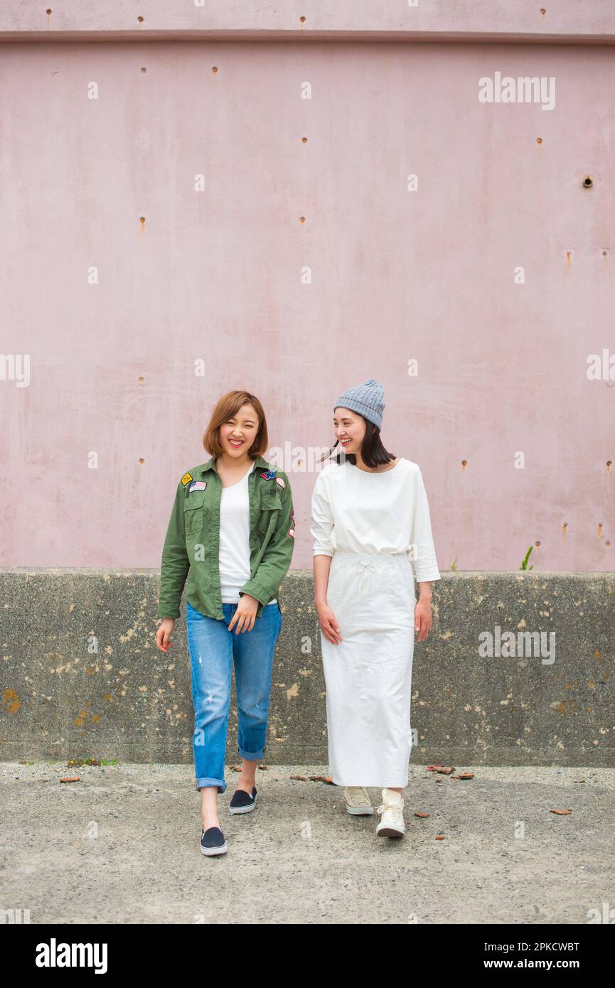 2 women in their 20s talking with friends Stock Photo - Alamy