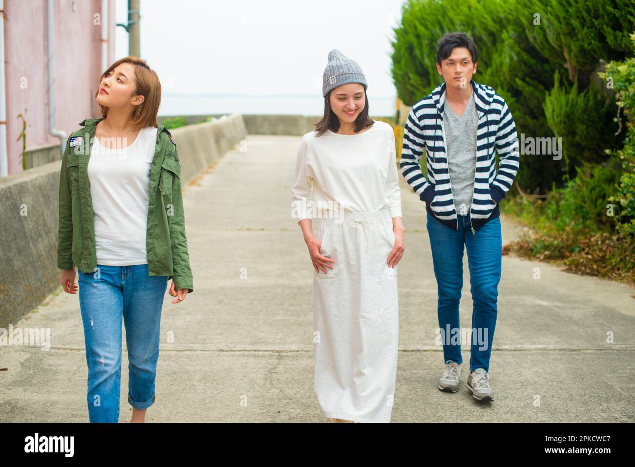 3 men and women in their 20s talking with friends while walking Stock ...