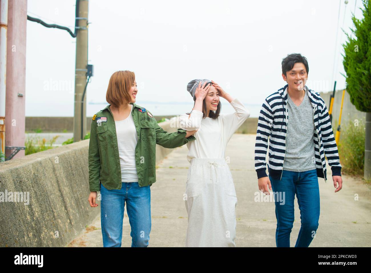 3 men and women in their 20s talking with friends while walking Stock ...