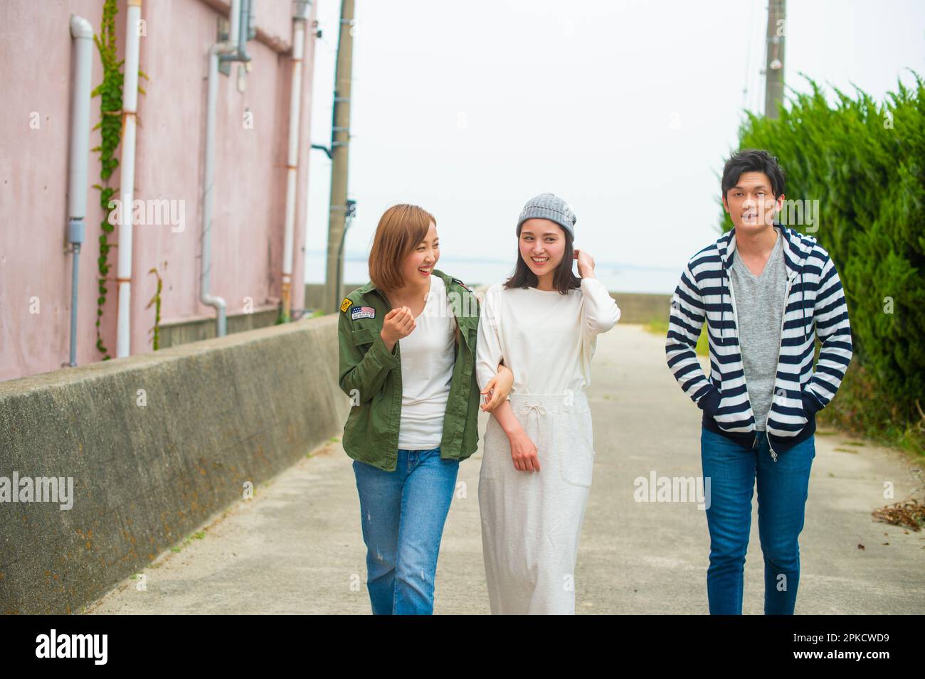 Three men and women in their 20s talking with friends while walking ...