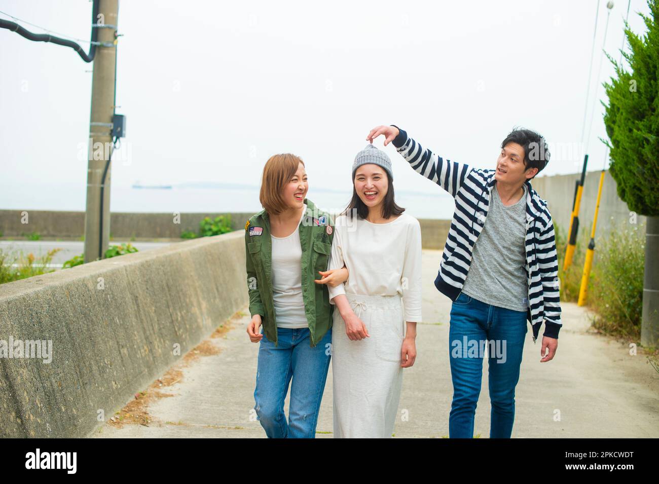 3 men and women in their 20s talking with friends while walking Stock ...