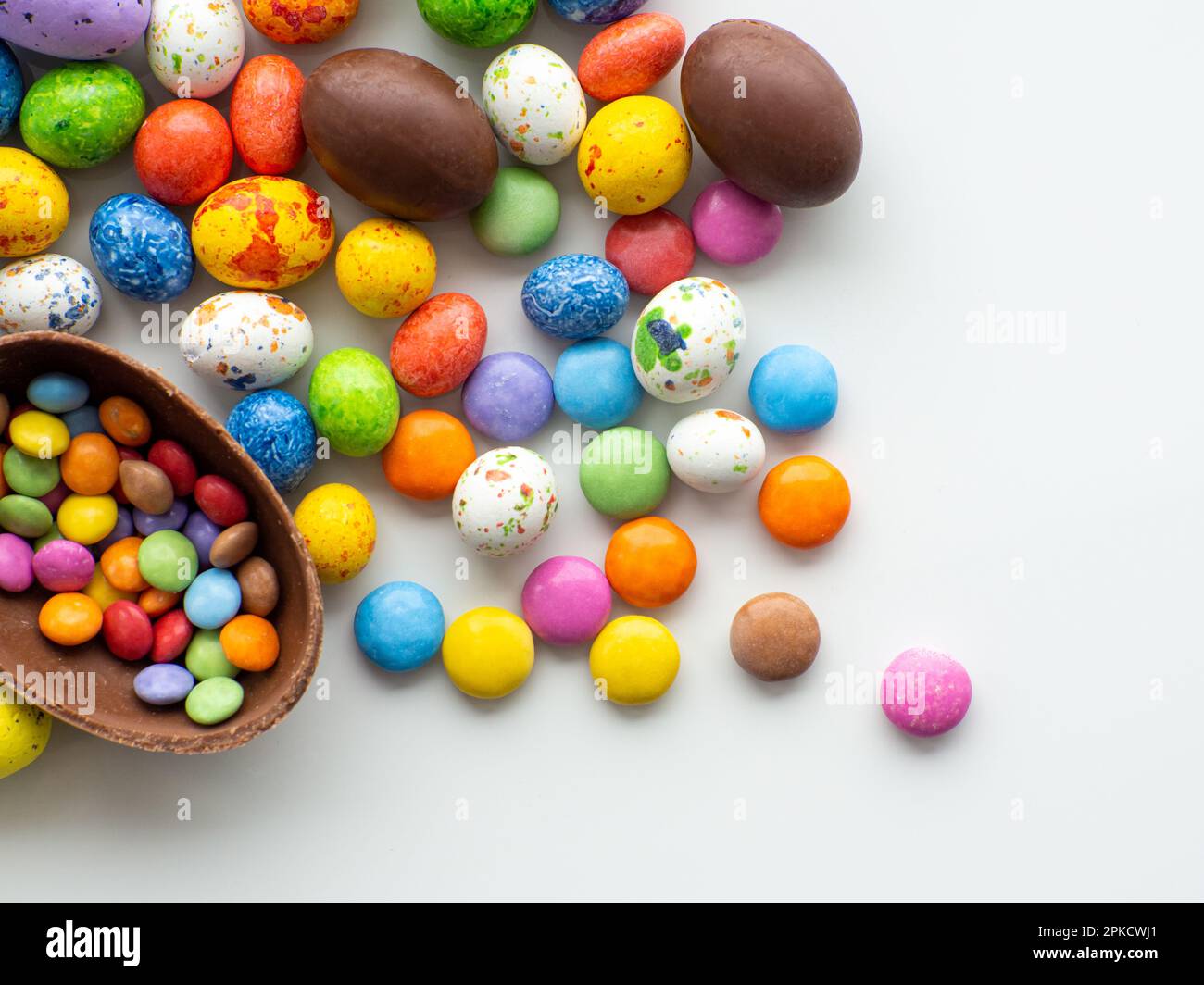 Colorful and chocolate easter eggs with sweet dragee on white ...