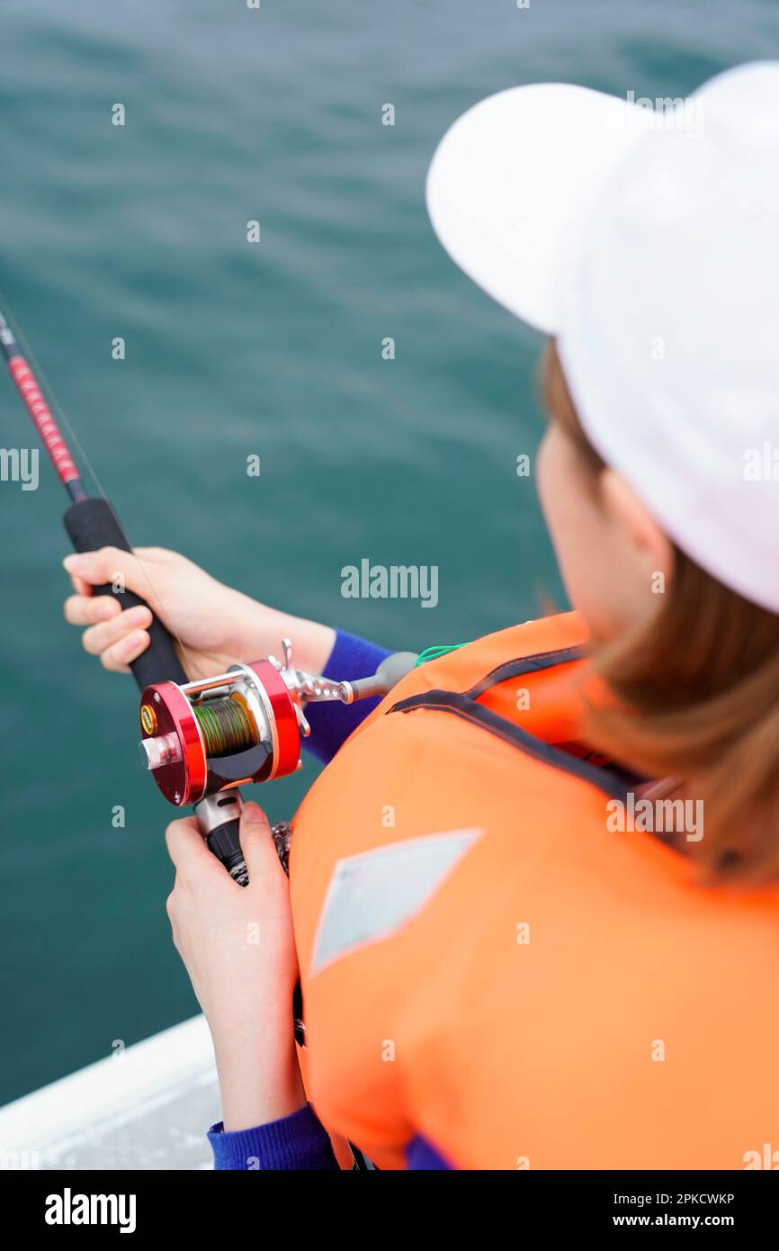 Hand holding a fishing rod Stock Photo - Alamy