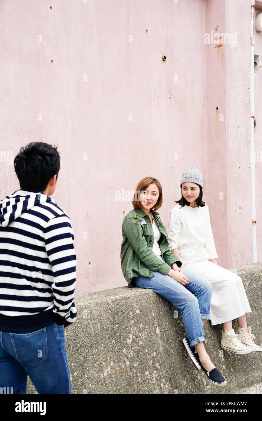 Three men and women in their 20s talking with friends Stock Photo - Alamy