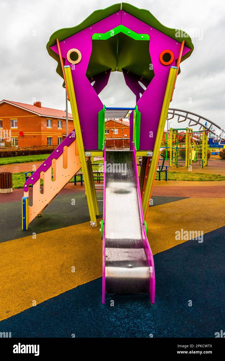Colorful outdoor playground equipment with slides, swings and carousels ...