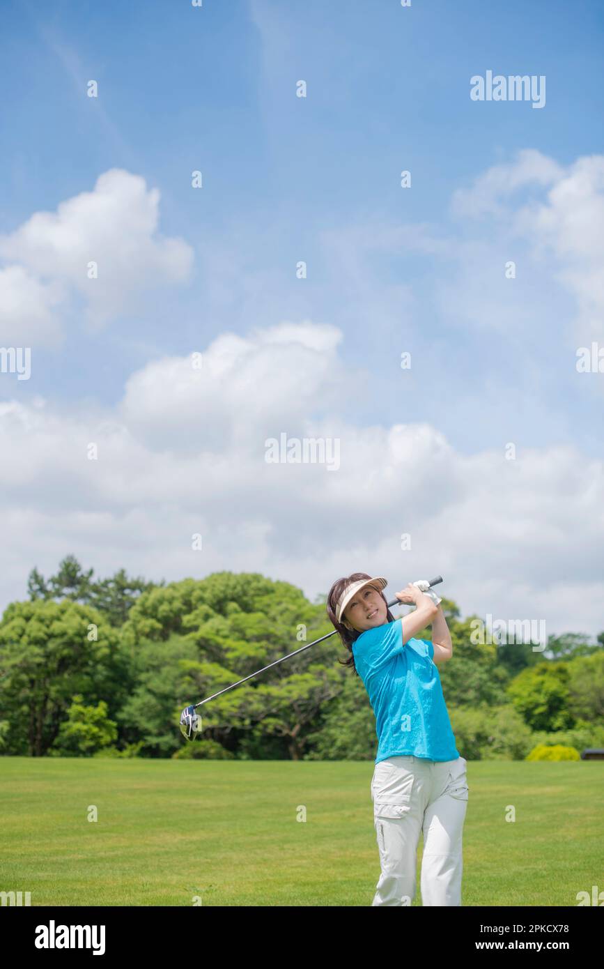 Middle-aged woman playing golf Stock Photo - Alamy