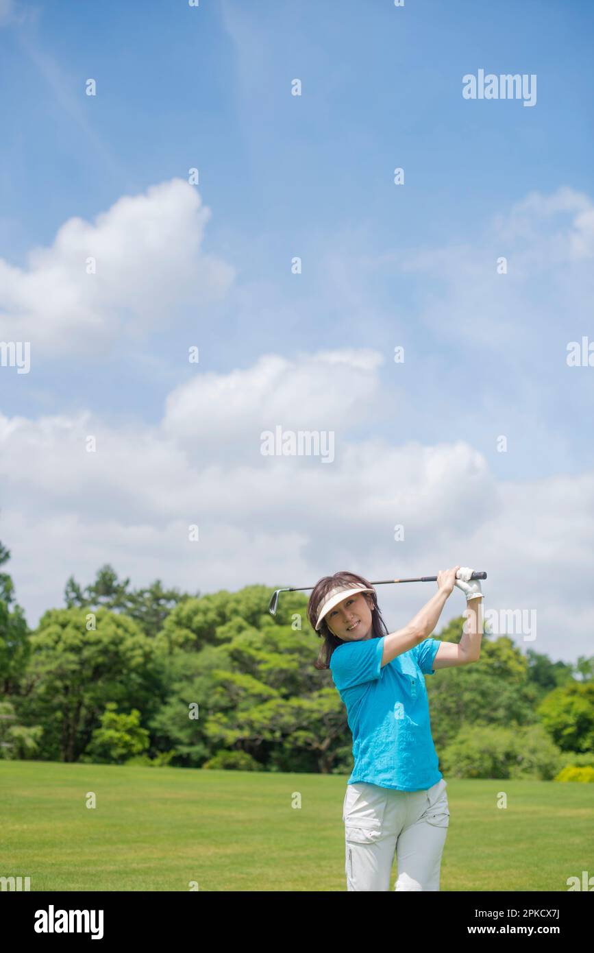 Middle-aged woman playing golf Stock Photo - Alamy