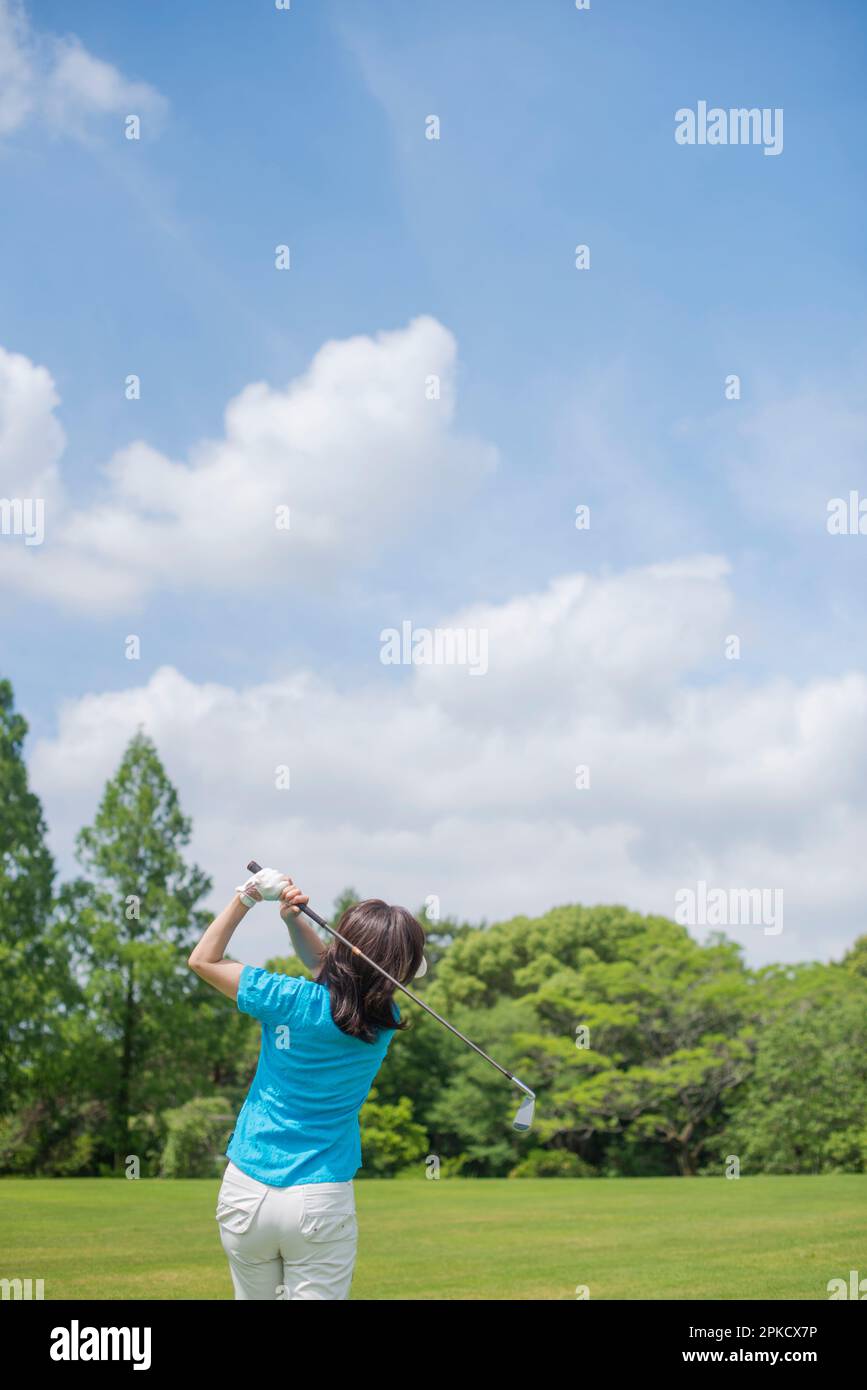 Middle-aged woman playing golf Stock Photo - Alamy