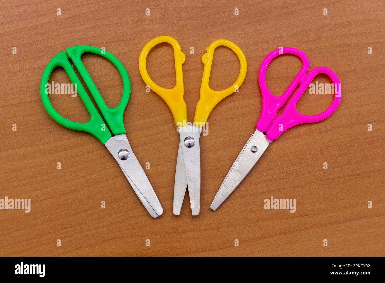Multi-colored stationery scissors on the surface of the office table ...