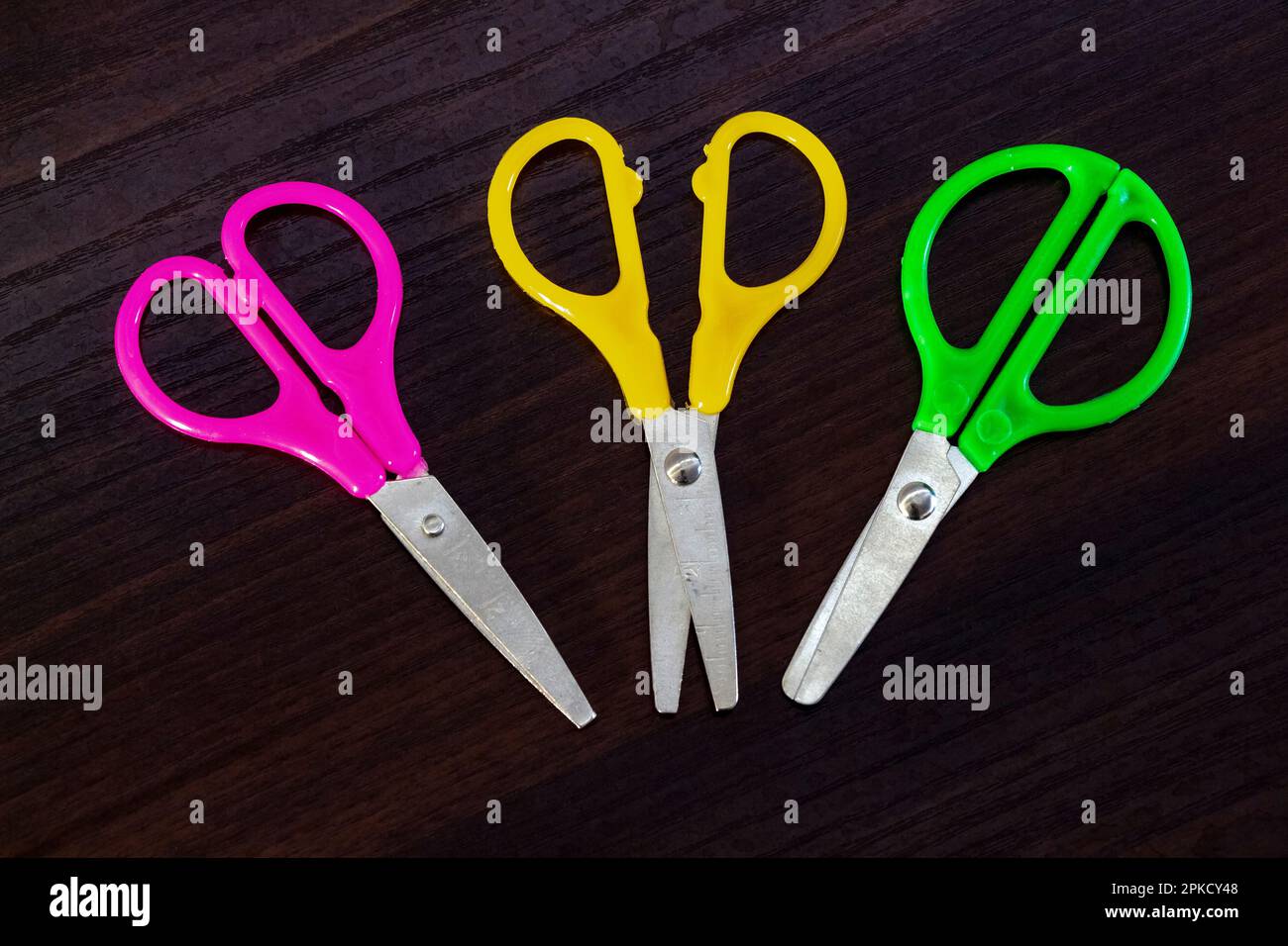 Multi-colored stationery scissors on the surface of the office table ...
