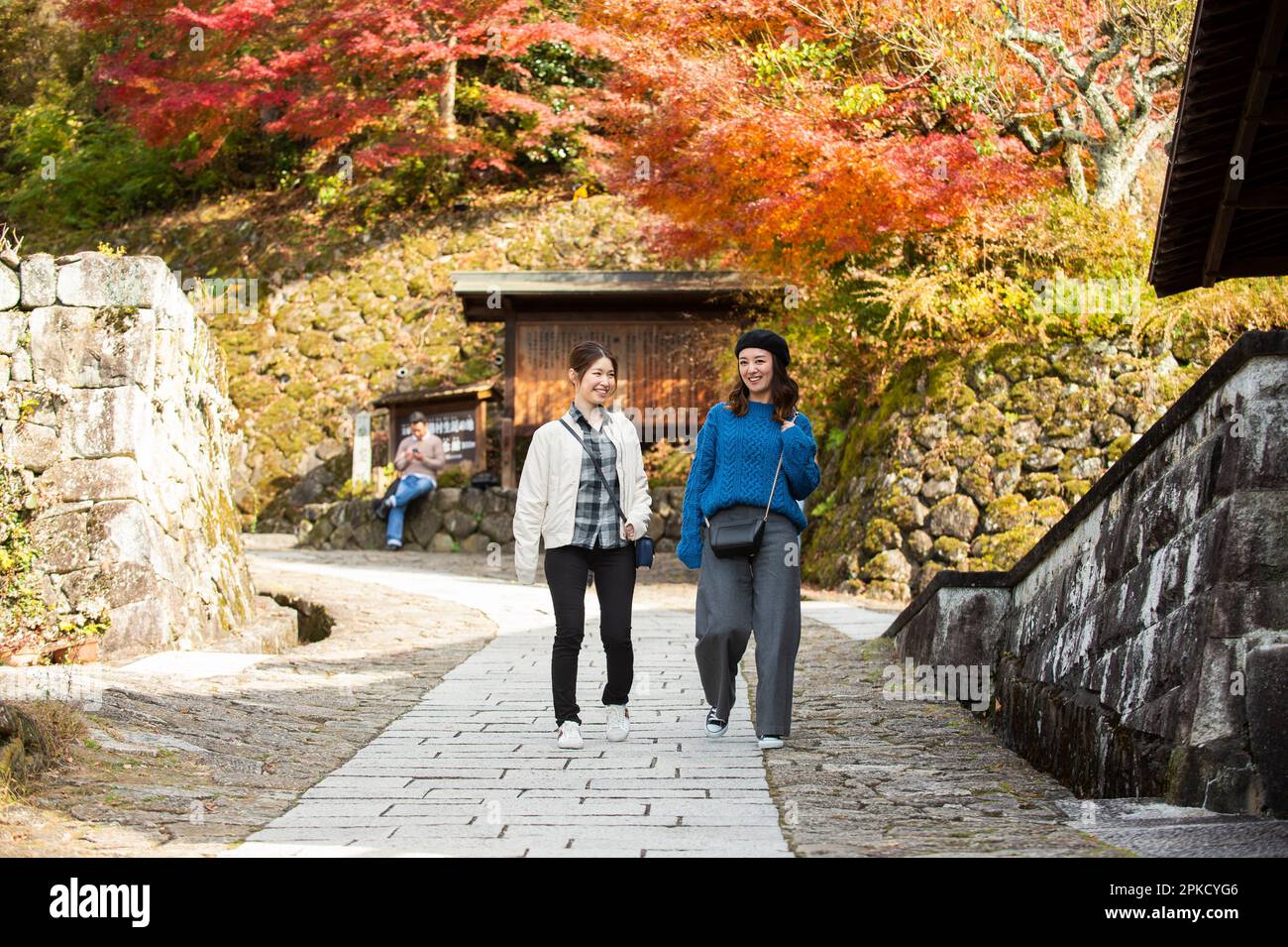 Two women strolling in a sightseeing spot while viewing the autumn ...