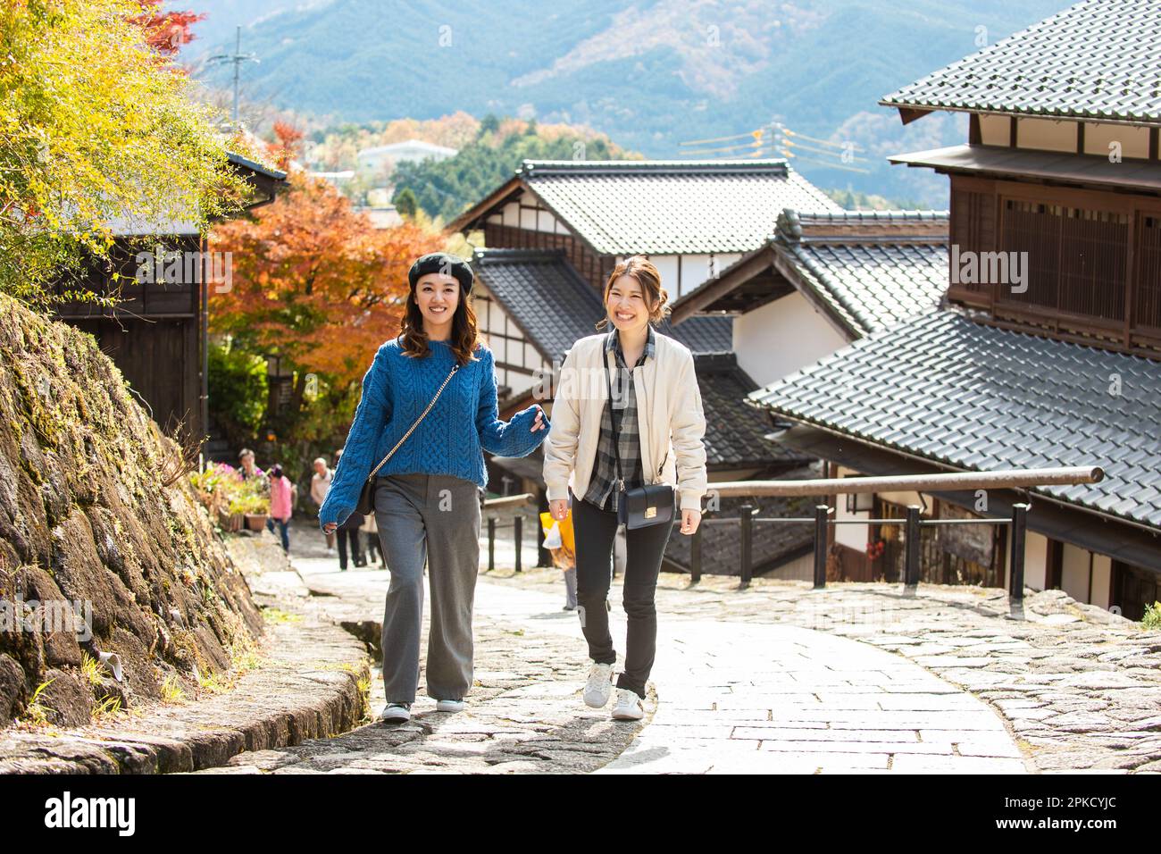 Two women strolling in a sightseeing spot while viewing the autumn ...
