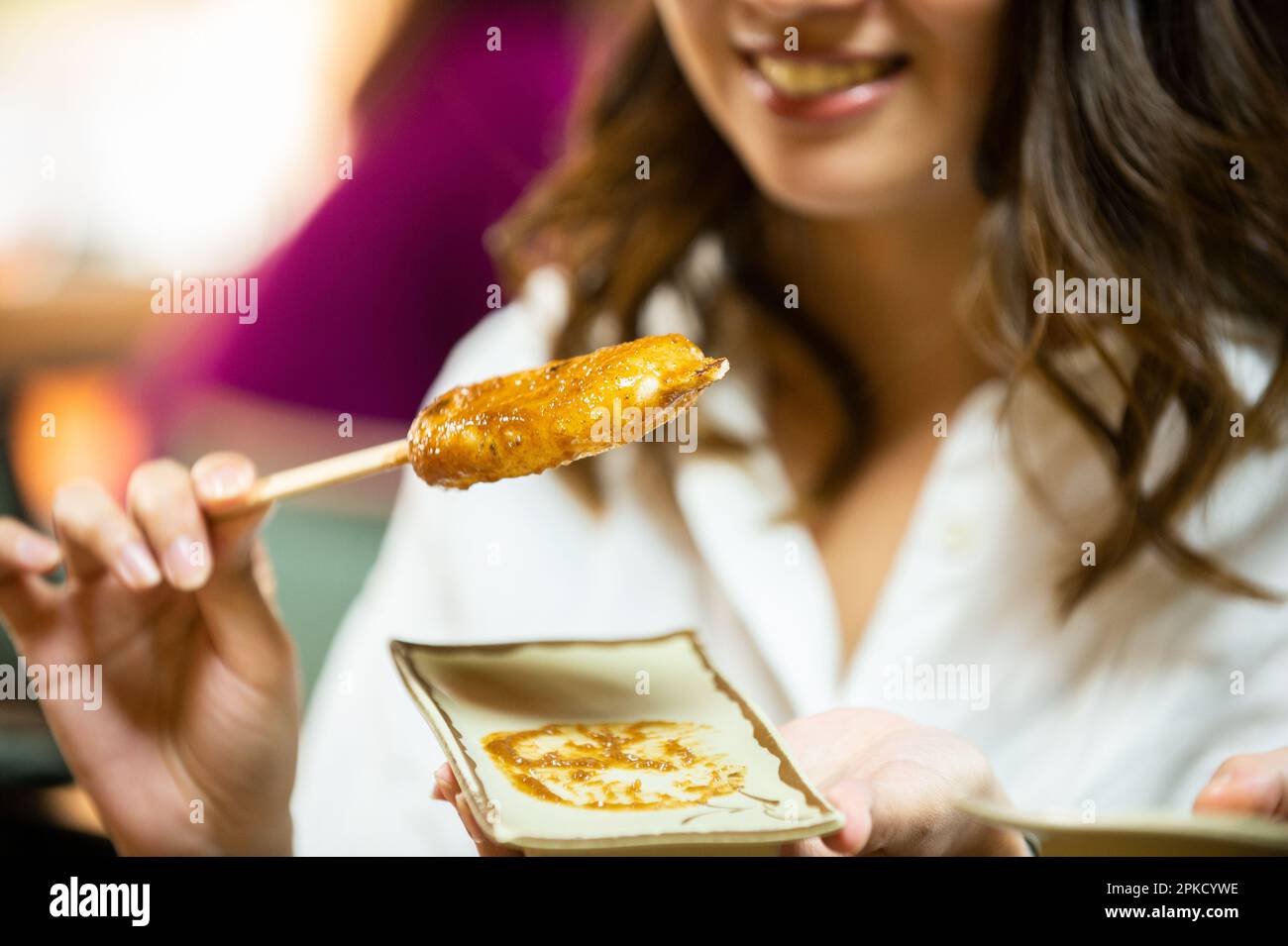 A woman eating a gohei-mochi (rice cake Stock Photo - Alamy