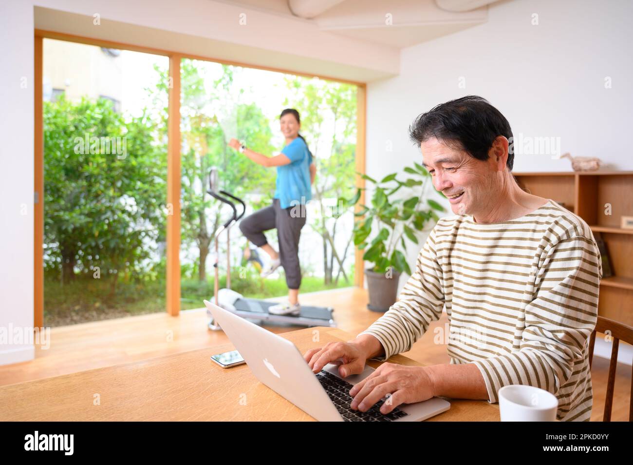 Teleworking middle-aged and older man with running machine Stock Photo ...