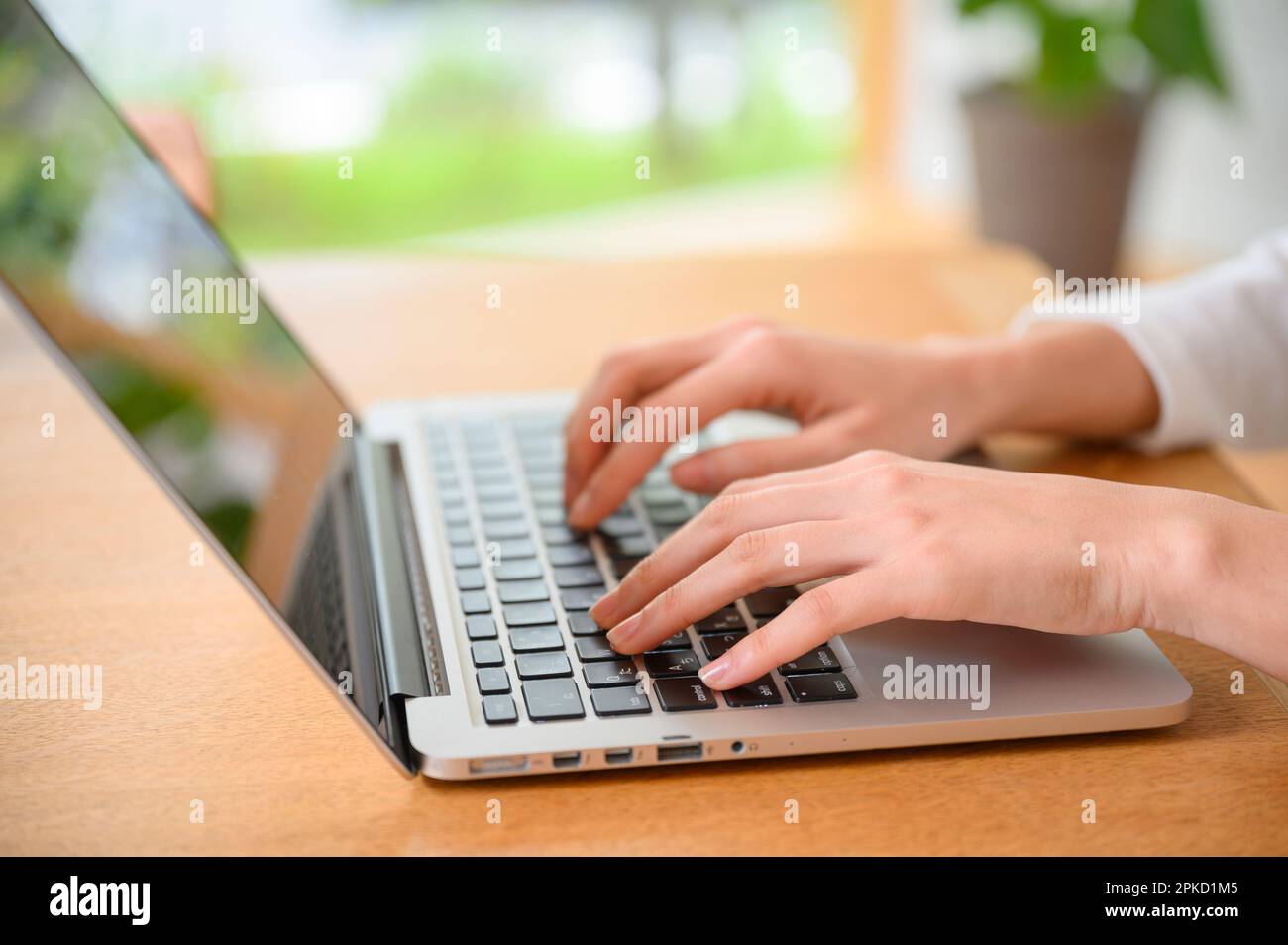 Two hands operating a notebook computer Stock Photo - Alamy