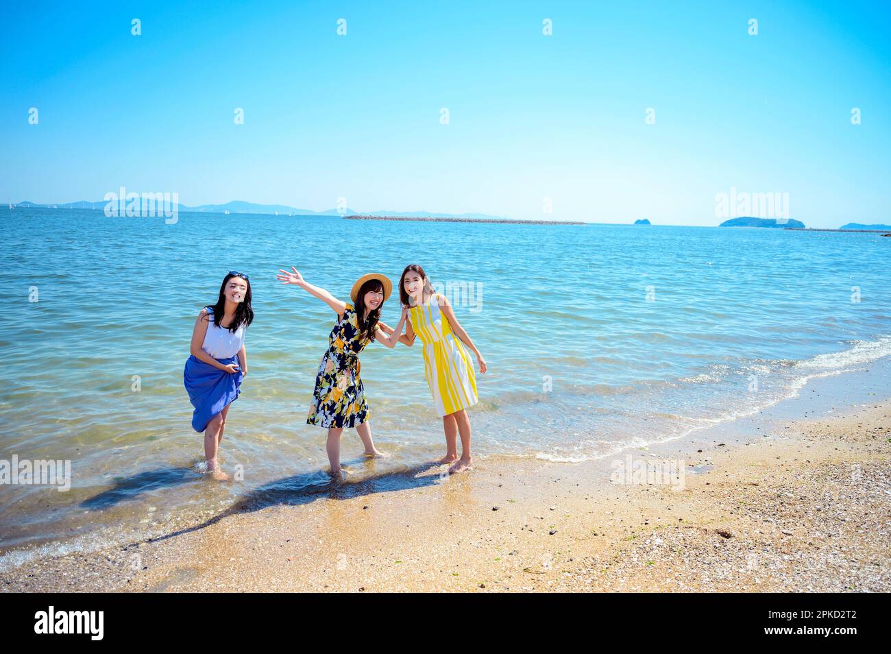 3 women traveling to a sea resort playing on the beach Stock Photo - Alamy