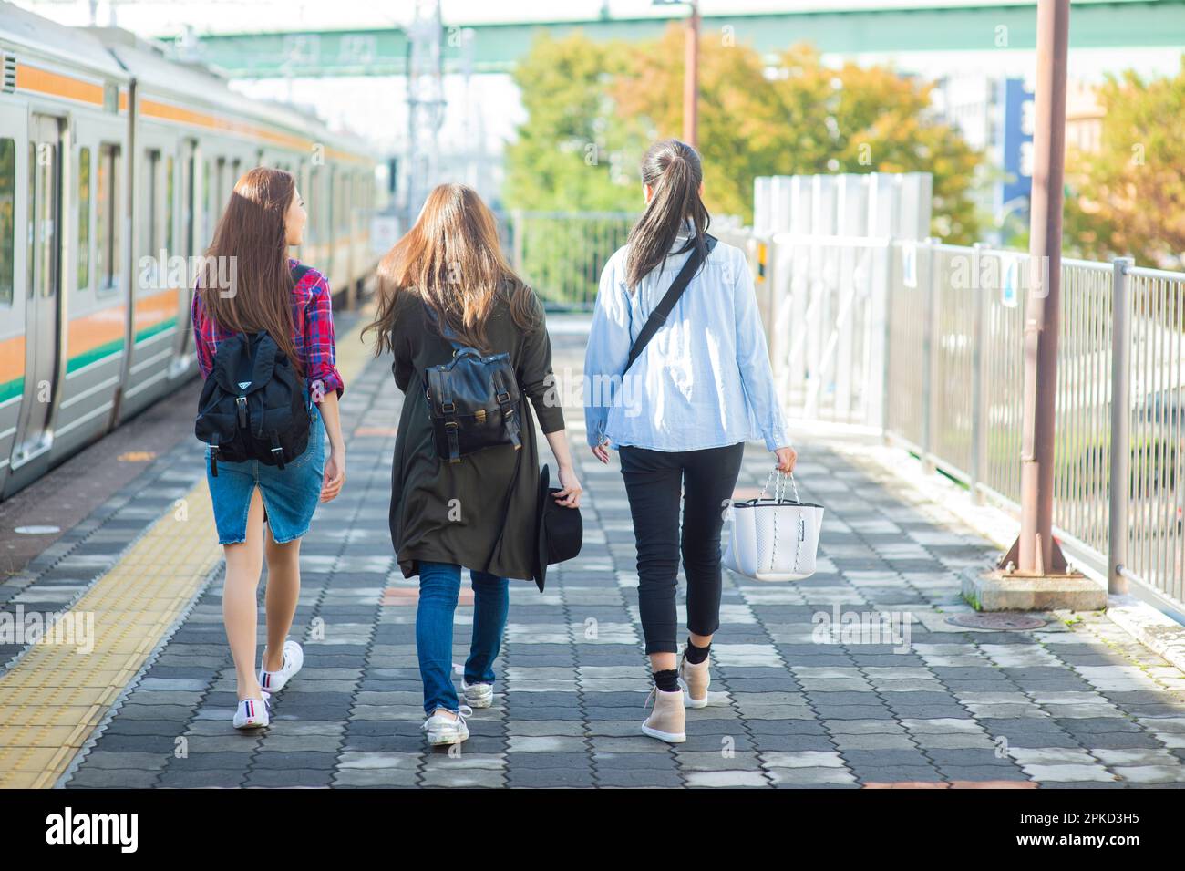 3 women walking on the platform of a train station Stock Photo - Alamy