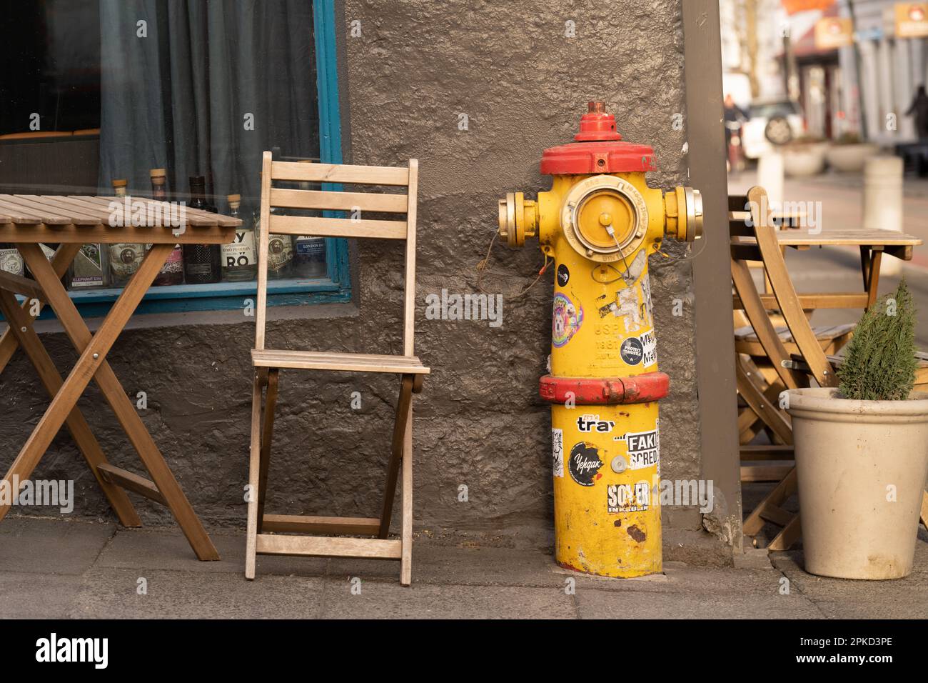 iconic steel Yellow and Red Fire Hydrant with stickers outside a coffee ...