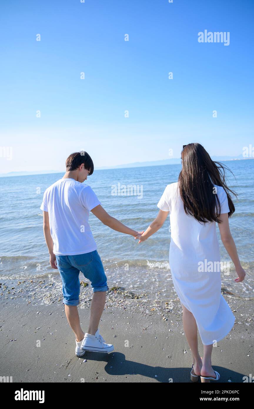 Couple strolling on the beach Stock Photo - Alamy
