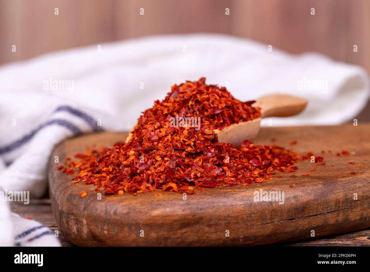Dried red pepper flakes. Spice chili pepper flakes in wooden spoon on ...