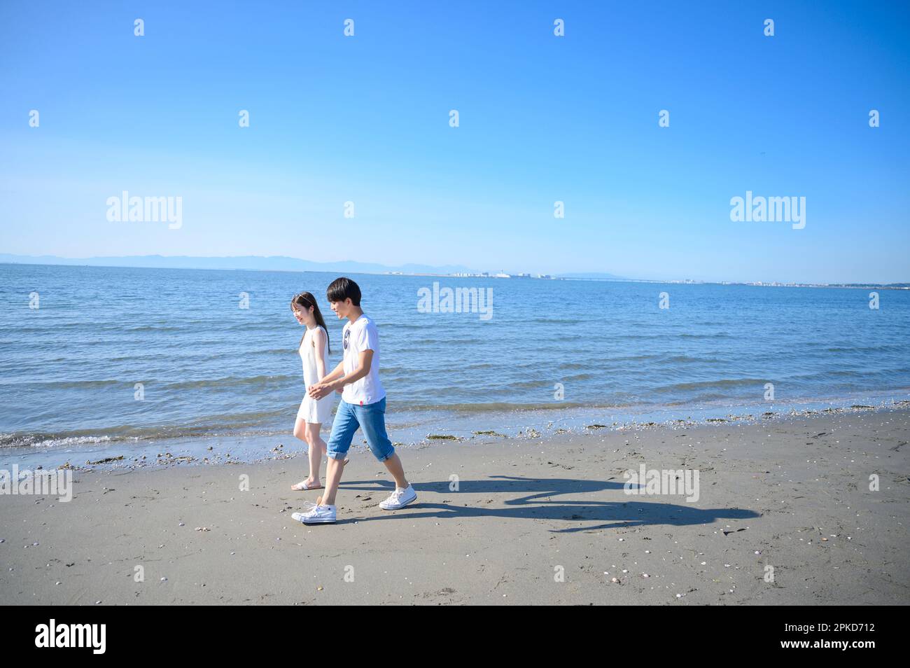 Couple strolling on the beach Stock Photo - Alamy
