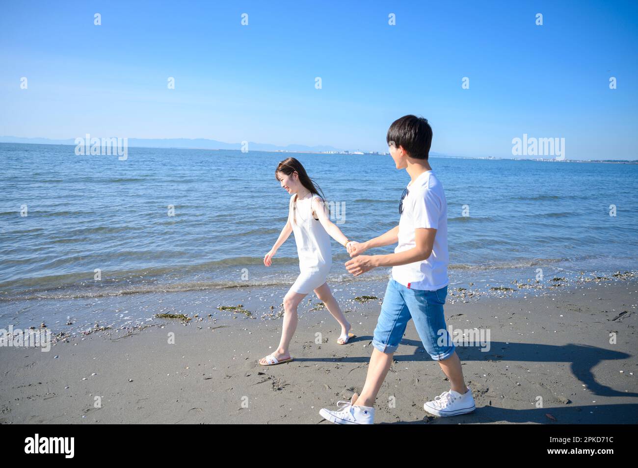 Couple strolling on the beach Stock Photo - Alamy