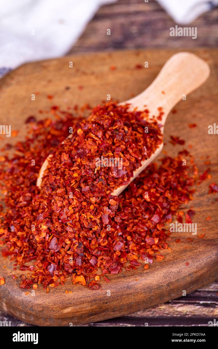 Dried red pepper flakes. Spice chili pepper flakes in wooden spoon on ...