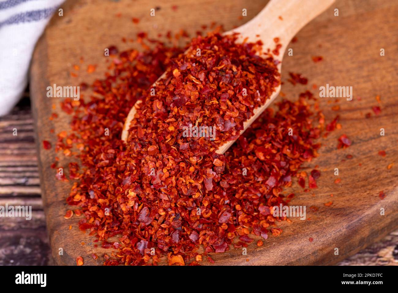 Dried red pepper flakes. Spice chili pepper flakes in wooden spoon on ...