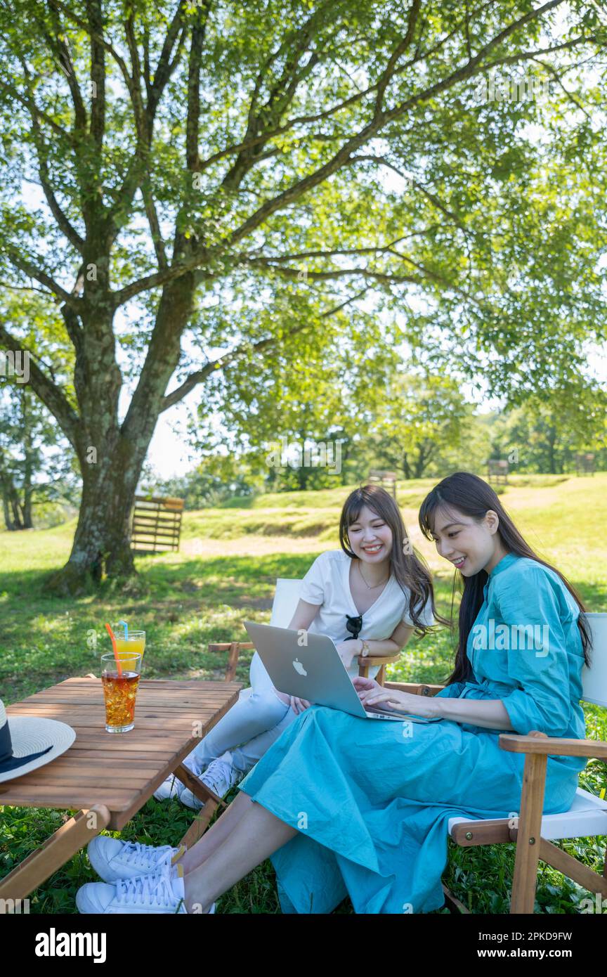 Two women working remotely at a campsite in the highlands Stock Photo ...