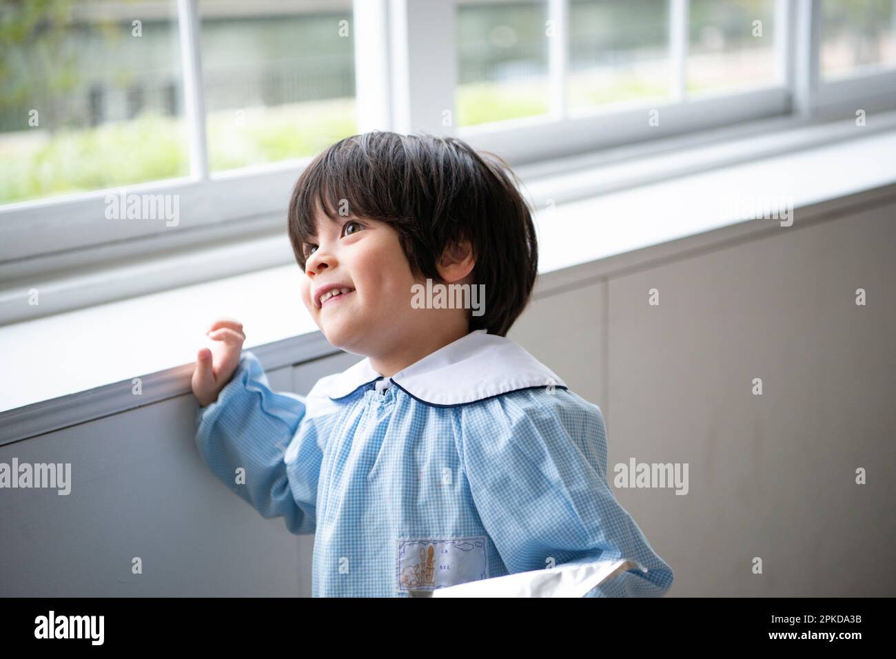 Smiling preschooler by the window Stock Photo - Alamy