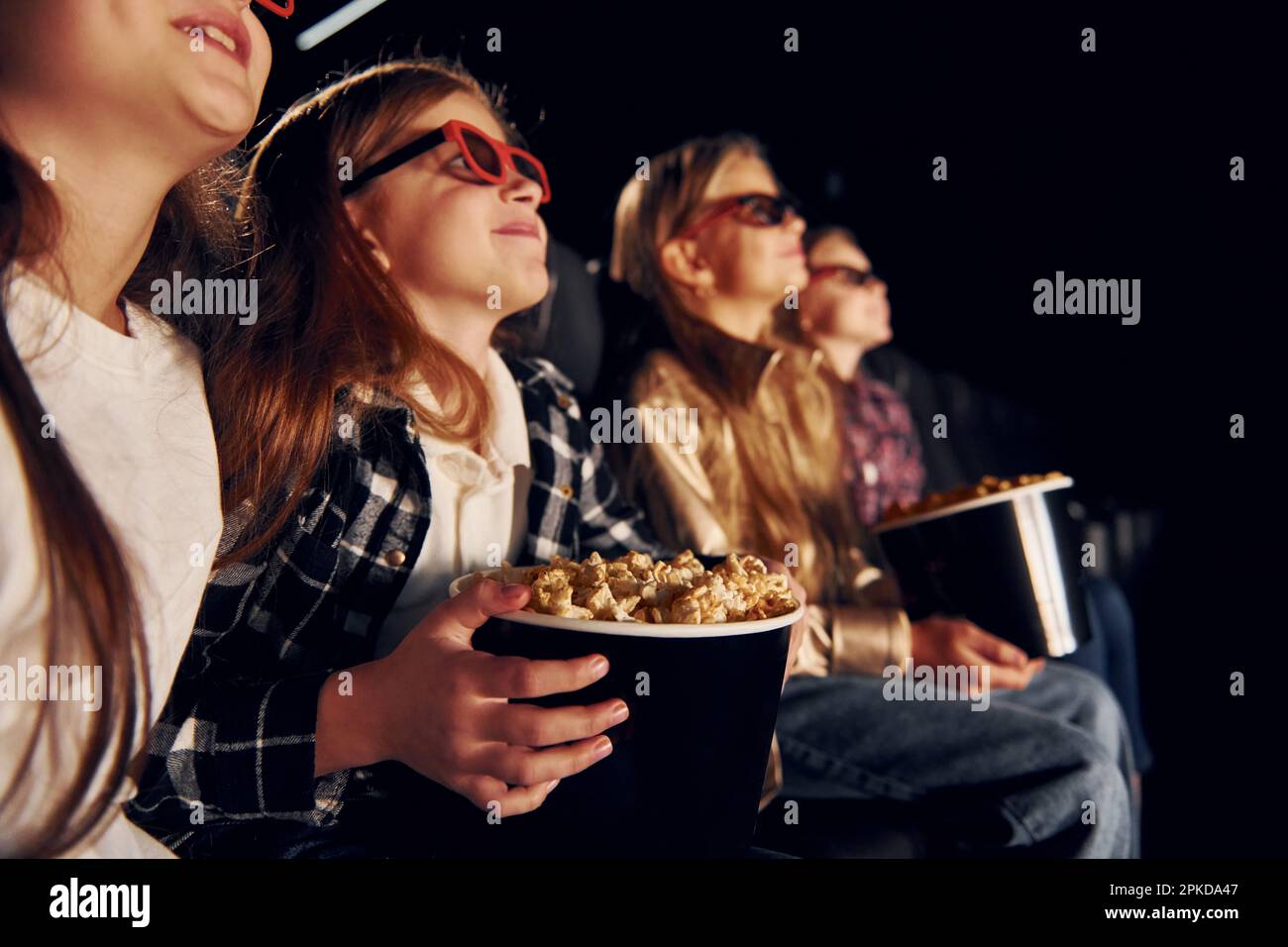 Interesting movie. Group of kids sitting in cinema Stock Photo - Alamy