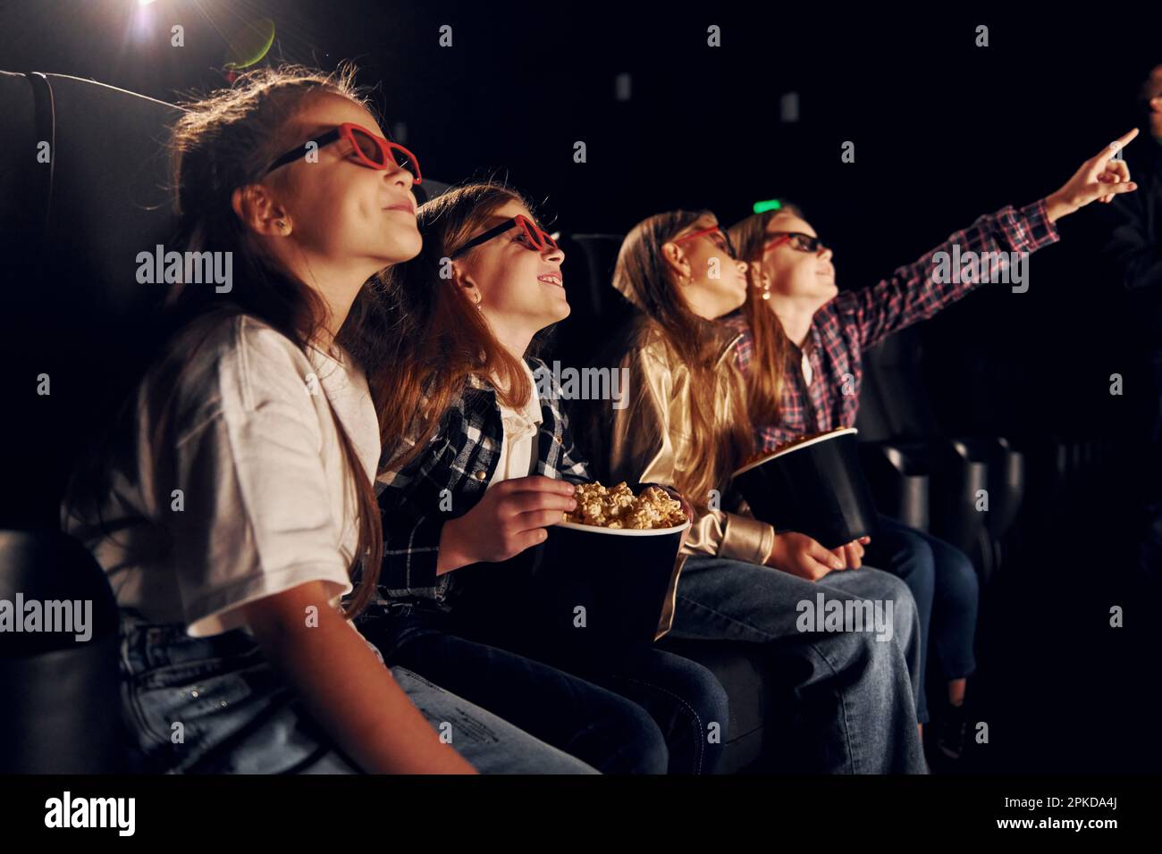 Interesting movie. Group of kids sitting in cinema Stock Photo - Alamy