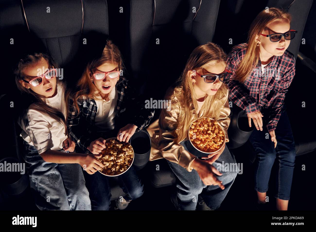 Top view. Group of kids sitting in cinema and watching movie together ...