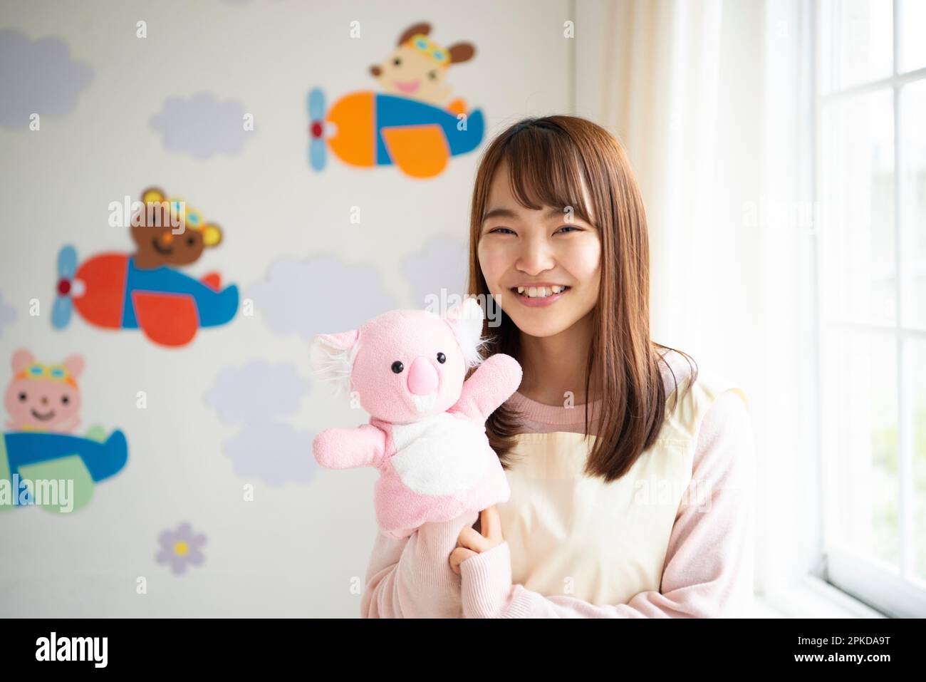 Nursery school teacher in front of a decorated wall Stock Photo - Alamy