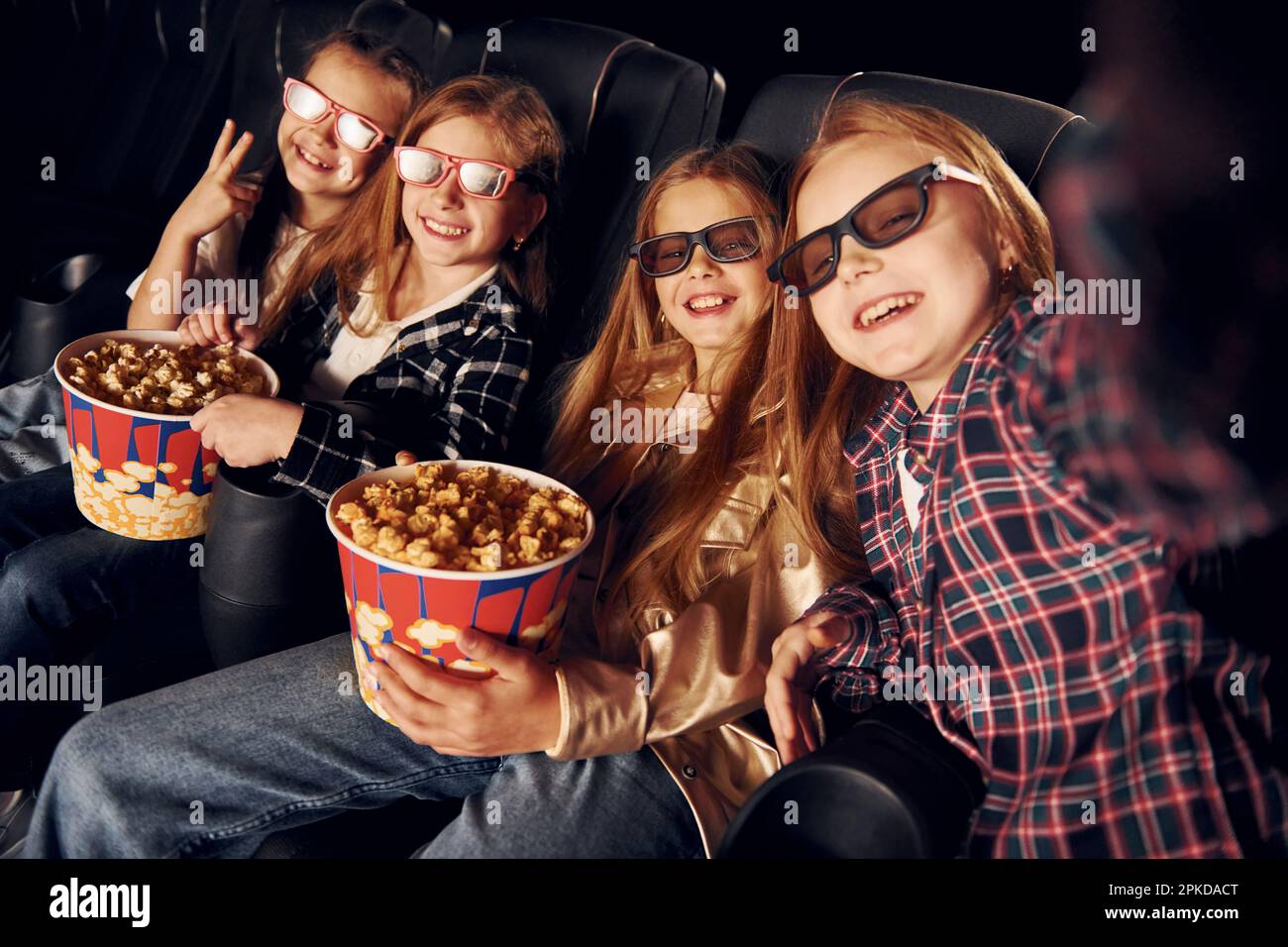Group of kids sitting in cinema and watching movie together Stock Photo ...