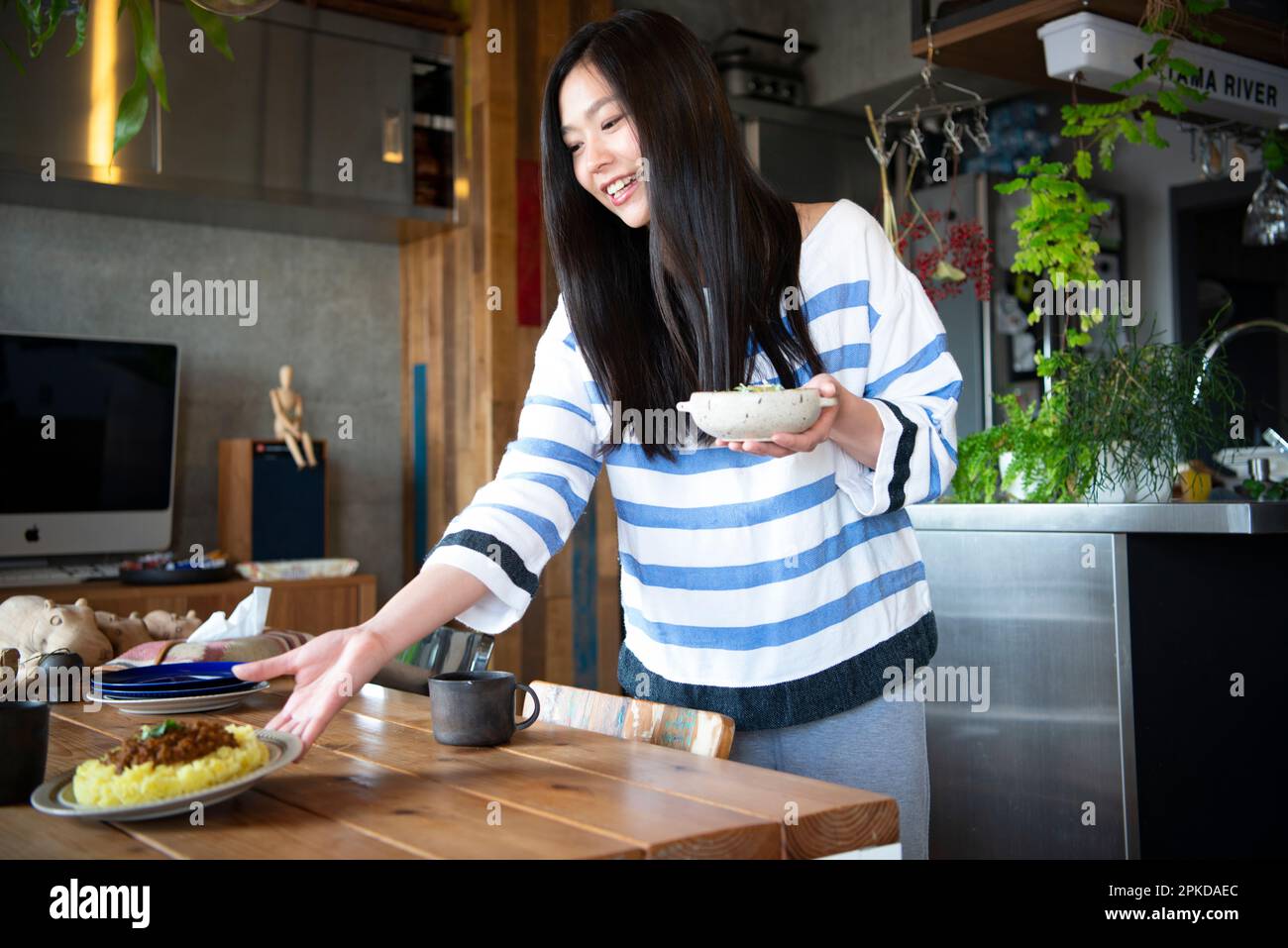 Woman putting food on table hi-res stock photography and images - Alamy