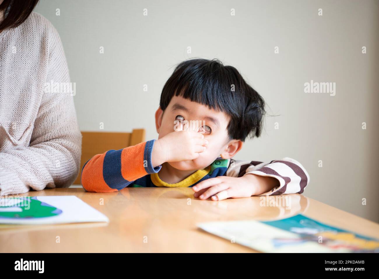 Boy making funny face at the table Stock Photo - Alamy