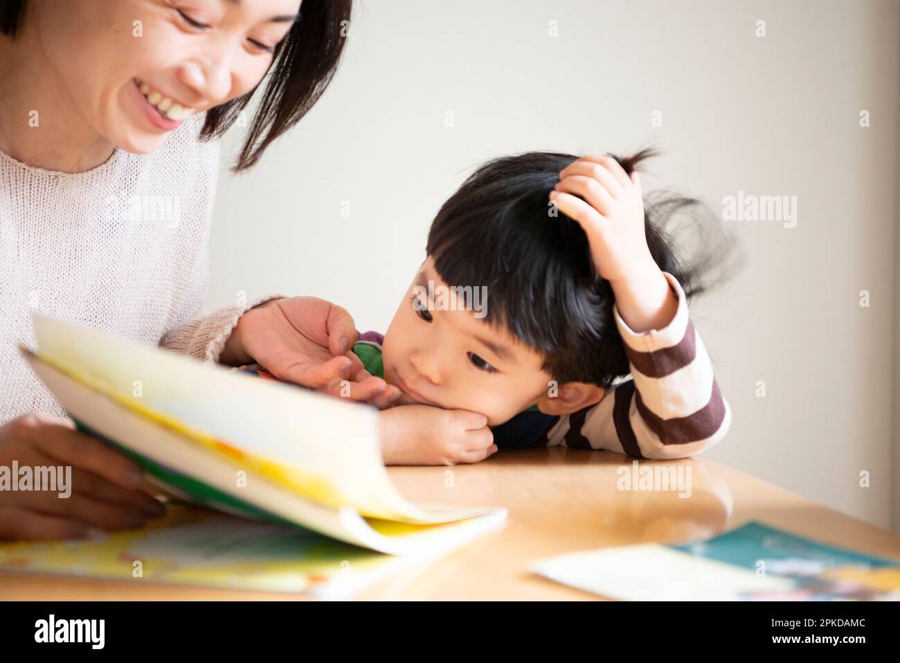 Parent and child reading picture book Stock Photo - Alamy