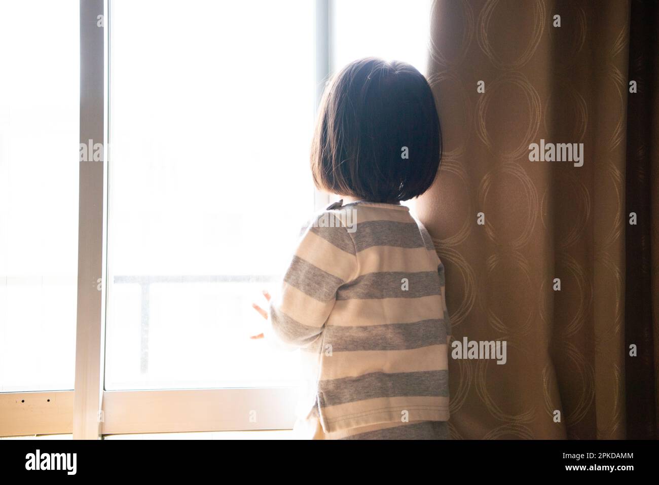 Girl looking out of window Stock Photo - Alamy