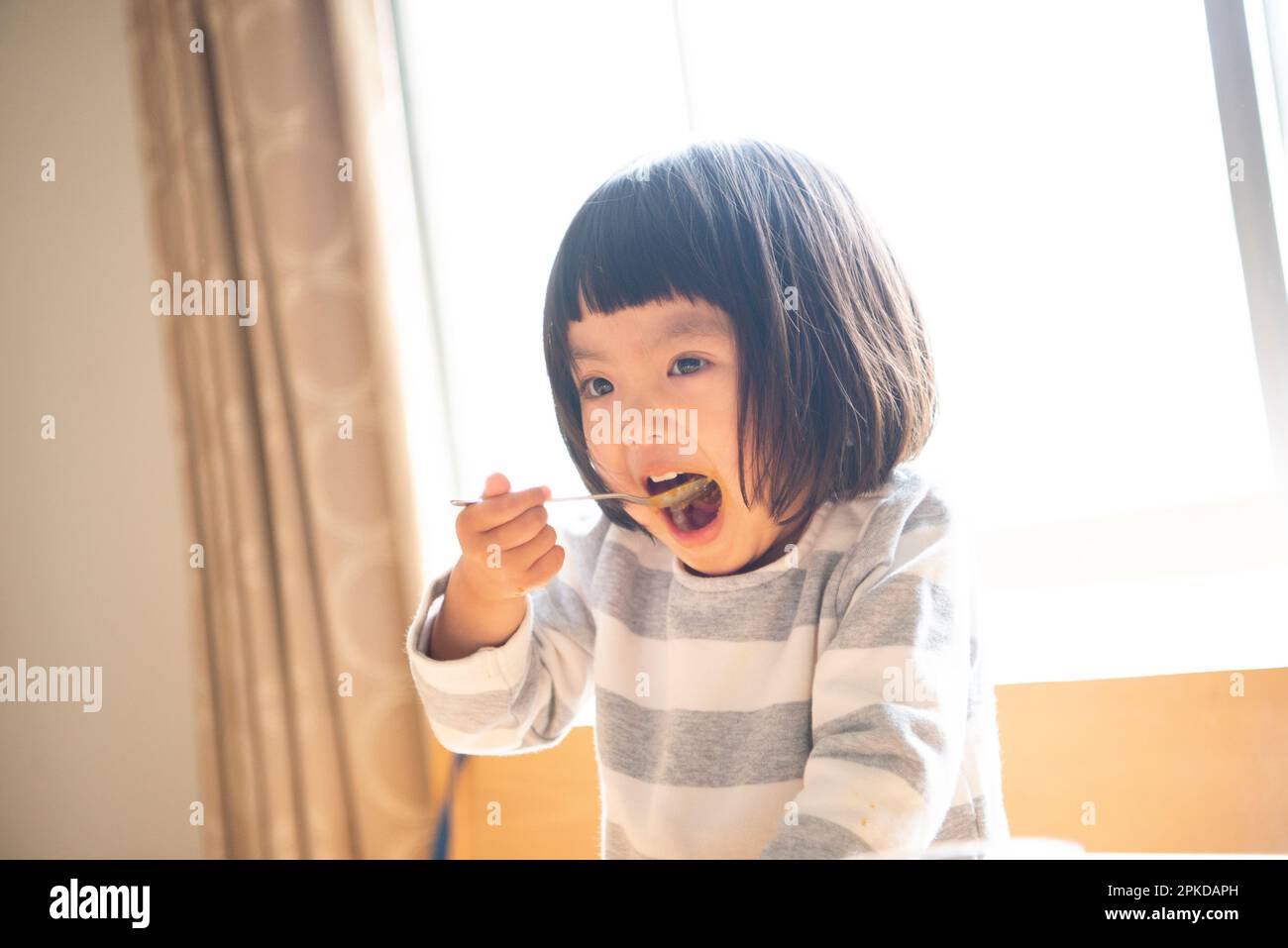 Girl eating rice Stock Photo - Alamy