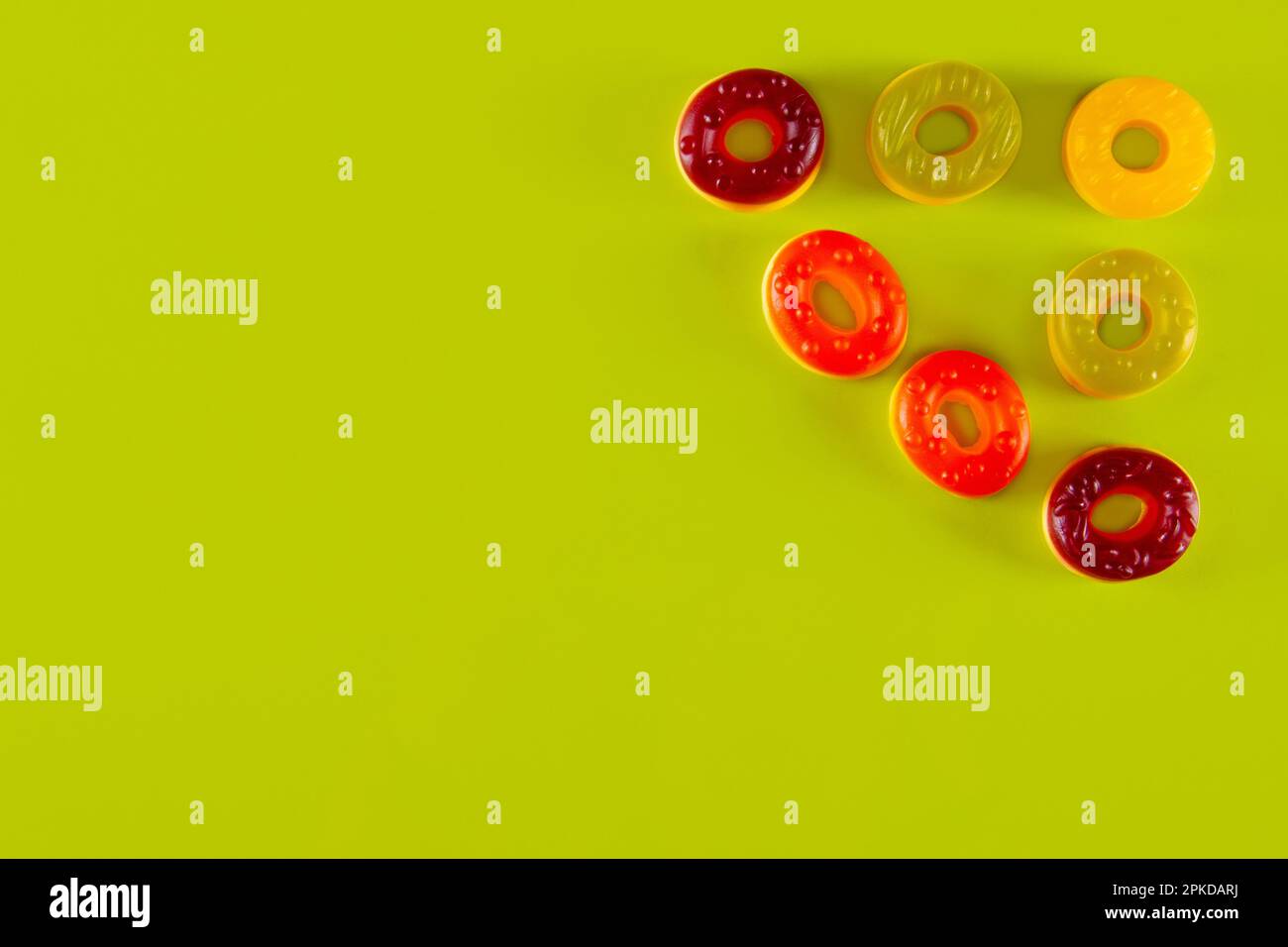 Triangle of round jelly candies at the corner of yellowish green ...