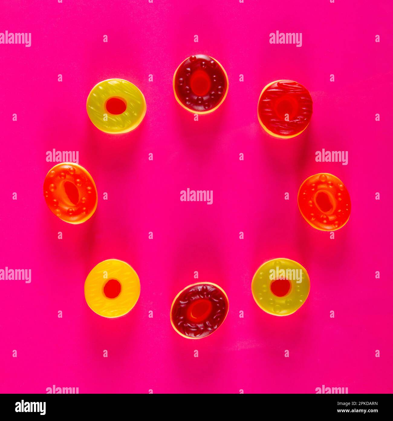 Circle of round jelly candies lie on vibrant pink background. Bright ...