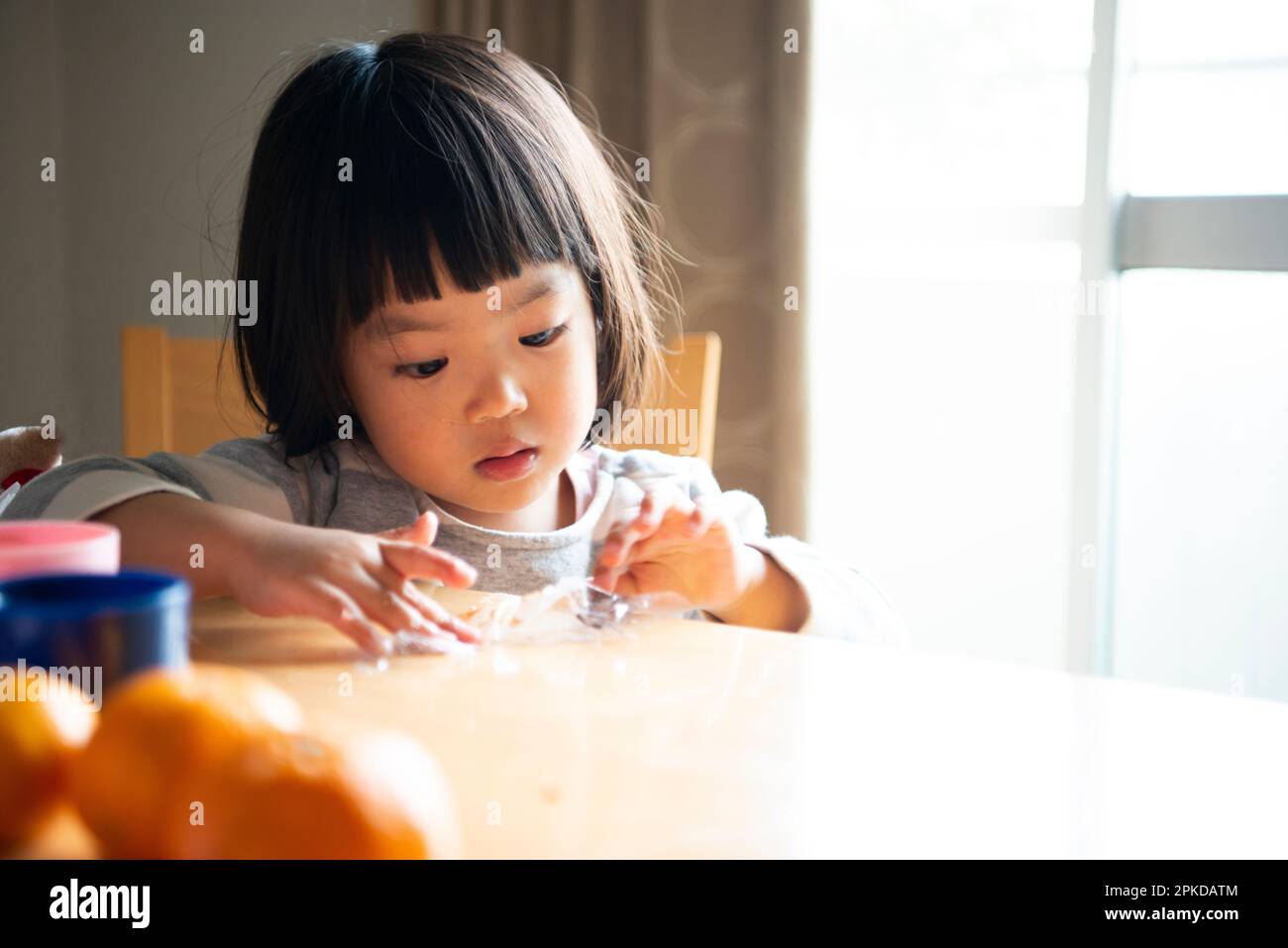 Girl eating snack at dining table Stock Photo - Alamy
