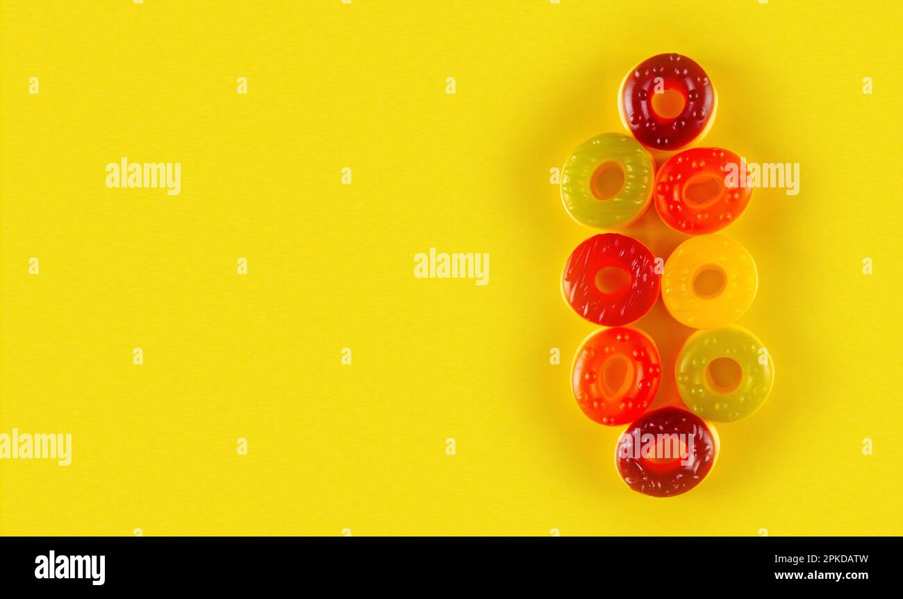 Eight round jelly candies lie on yellow background. Eye-catching ...