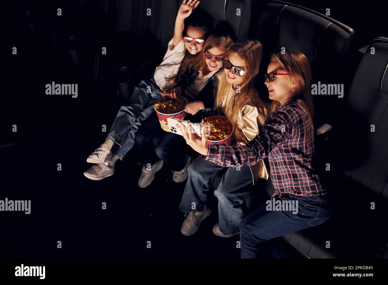 Conception of entertainment. Group of kids sitting in cinema and ...