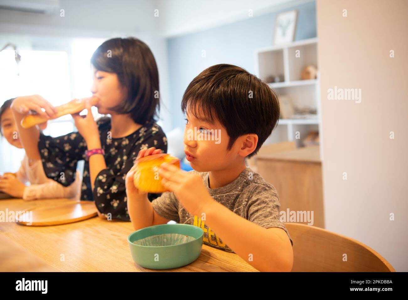 Children eating bread at the counter Stock Photo - Alamy
